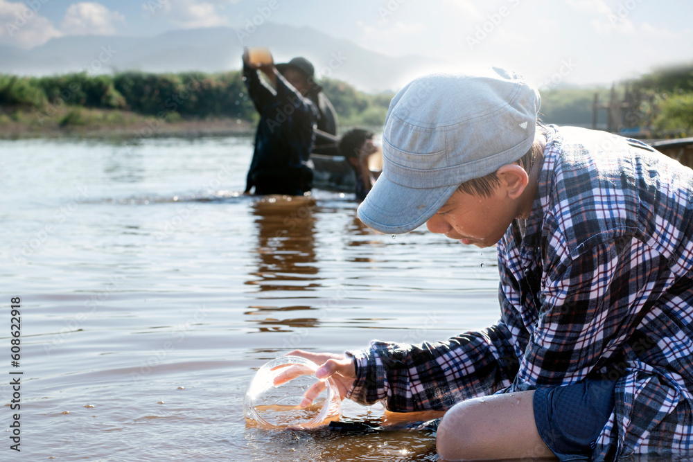 Stockfoto Asian boy is collecting river water samples in transparent ...