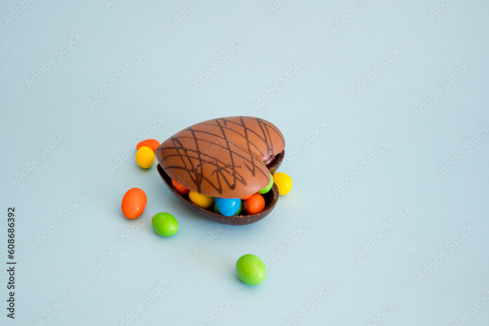 Vista lateral de un corazón de chocolate relleno de bolitas de colores ...