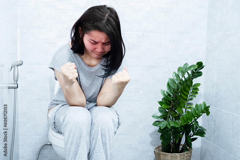 chronic constipation concept with Asian woman sitting in the toilet ...