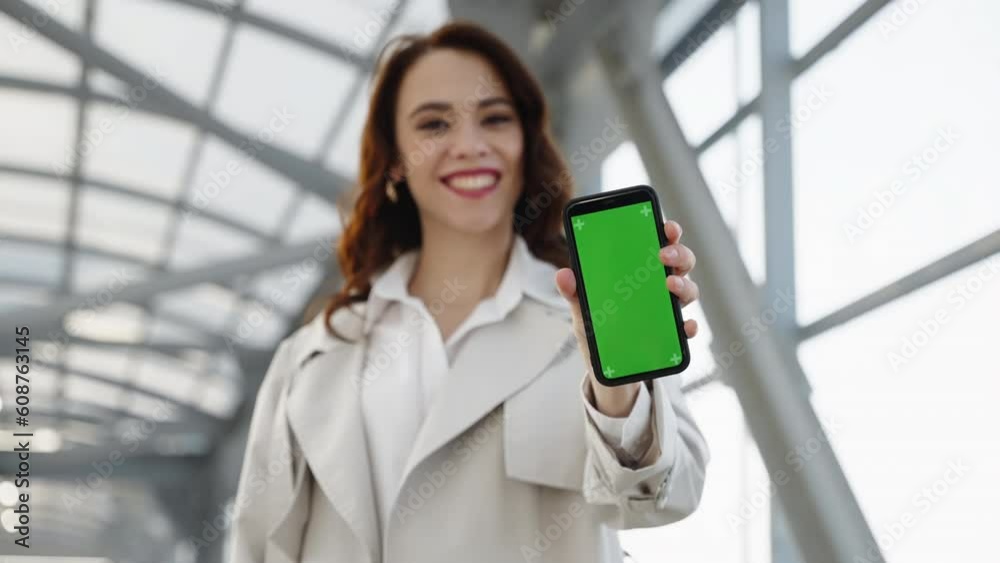 Beautiful girl shows a phone with a green screen for inserting content ...