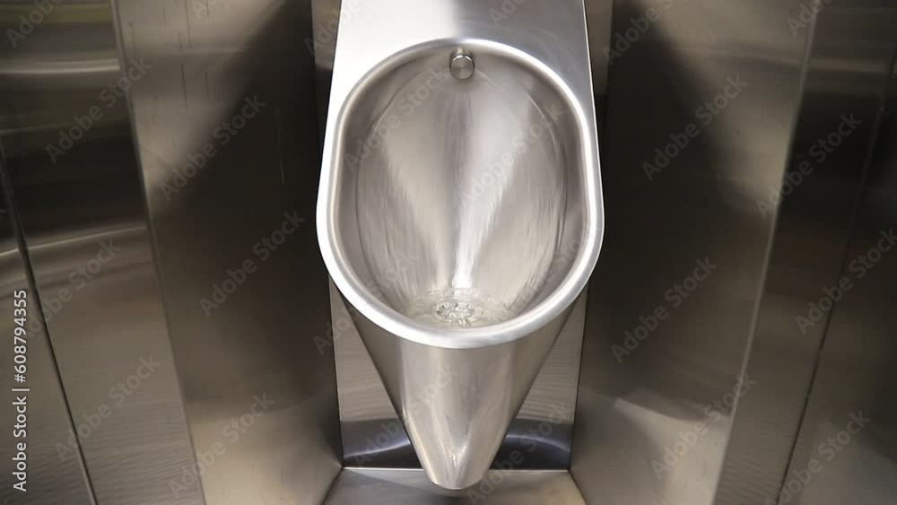 Sanitary metal urinal, toilet bowl in public bathroom with hygienic ...