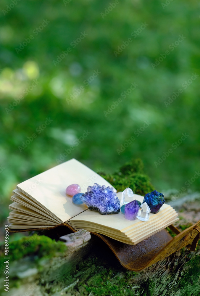 open witch book and gemstones on natural blurred forest background ...