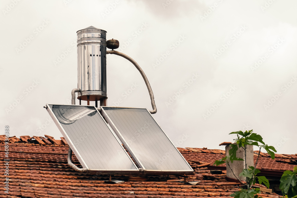 Foto de Barrel and solar panels for heating water from sun rays in ...