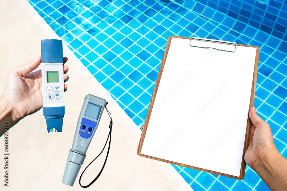 Digital water tester with blank paper clipboard over clear swimming ...