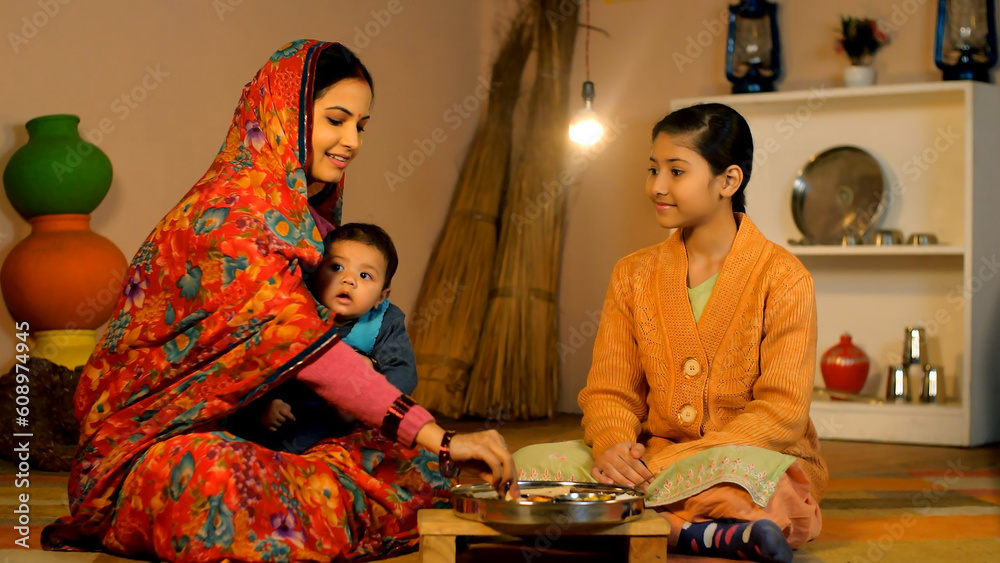 Village scene of a beautiful Indian mother happily feeding her young ...
