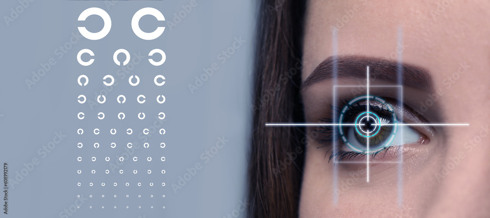 Vision test chart and laser reticle focused on woman's eye against ...
