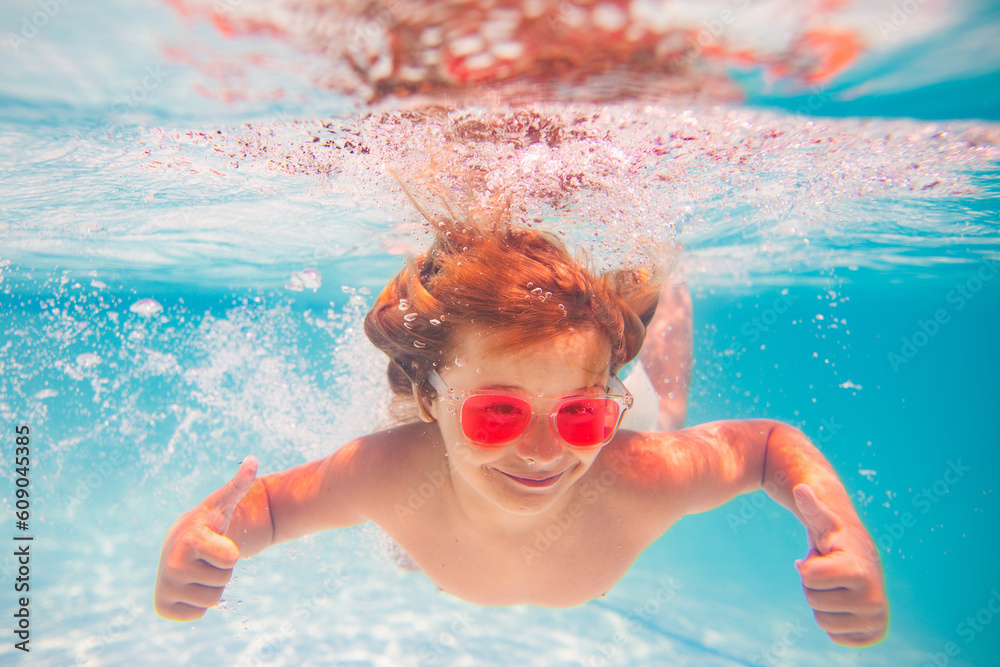 Child in swimming pool underwater with thumbs up. Underwater kid swim ...