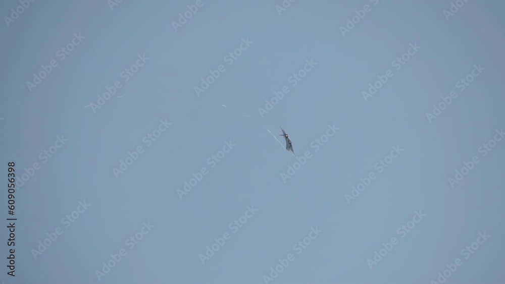 A jet military fighter attack aircraft is flying against the blue sky ...