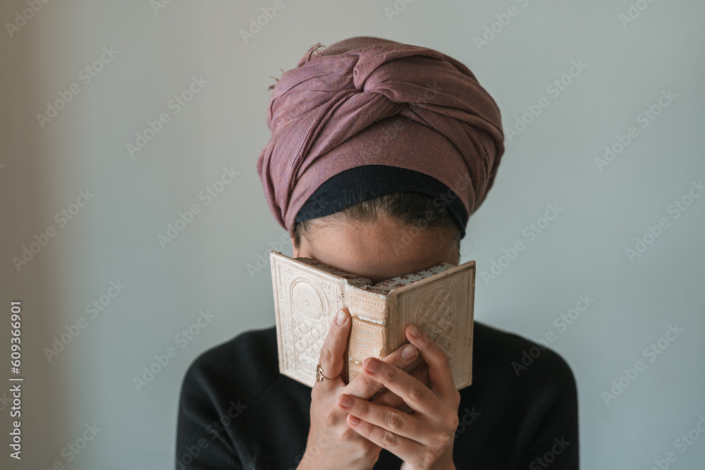 Young jewish woman with a covered head prays with a siddur (jewish ...