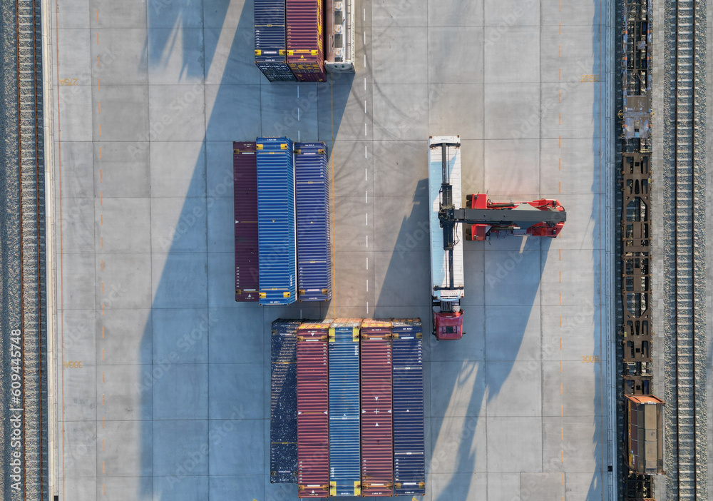 Aerial top down view crane loading container from container truck to ...