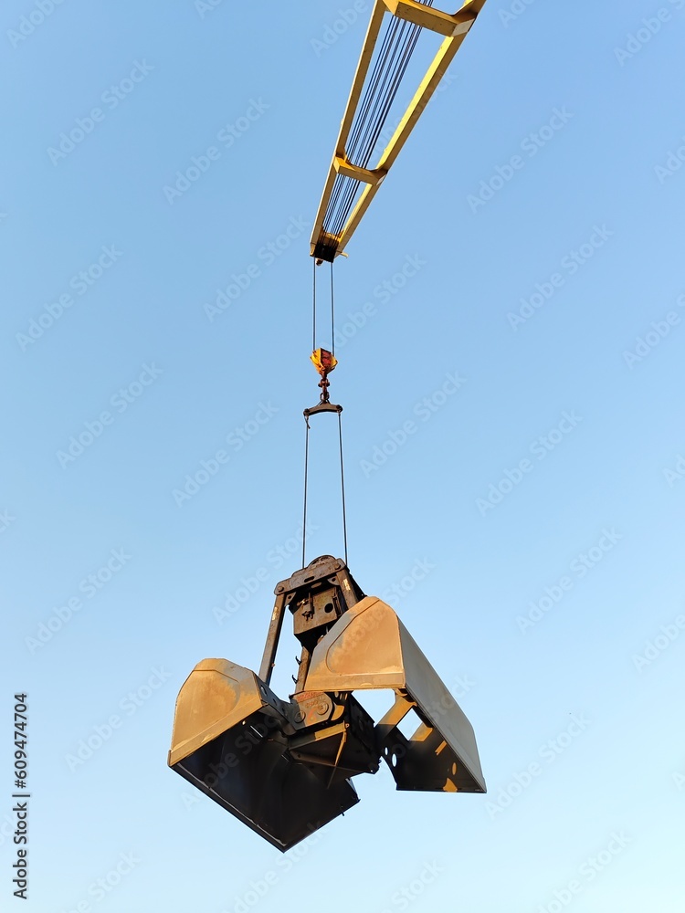 A grab is grabbing cargo in the hold of cargo ship or a bulk carrier ...