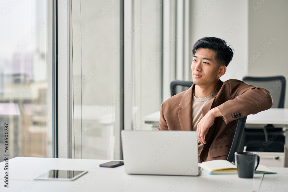 Thoughtful happy young Asian business man employee sitting with laptop ...