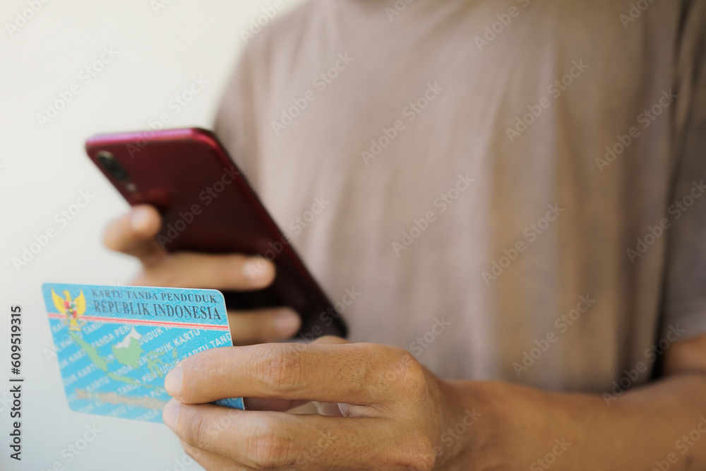 Asian man takes a photo of his Indonesian National Identity Card (KTP ...