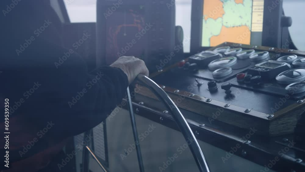 Boat captain carefully steers ship with large helm wheel, with sonar ...