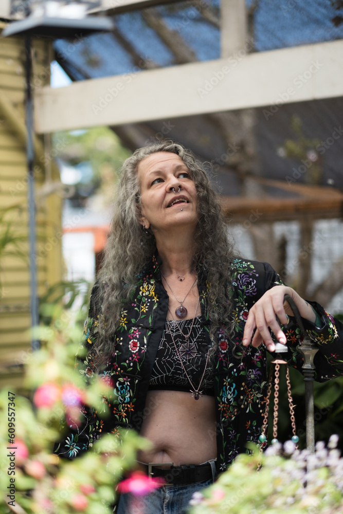 A queer senior citizen strikes a pose in their backyard, their bare ...