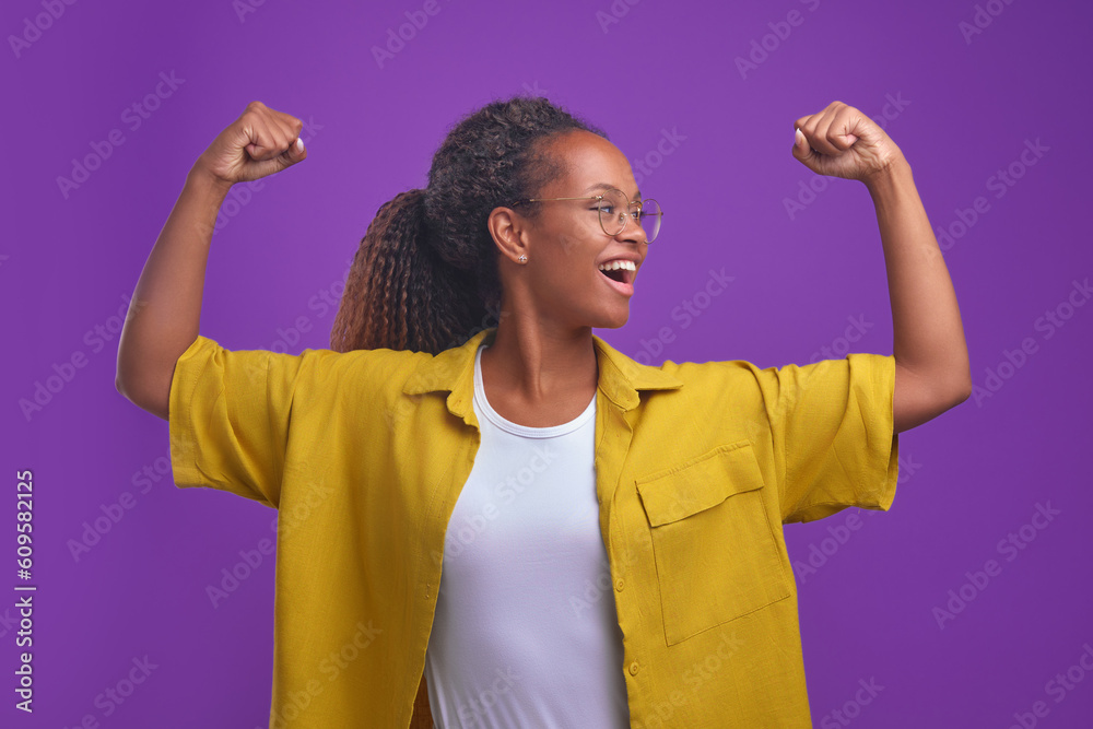 Young strong happy African American woman showing off biceps in ...