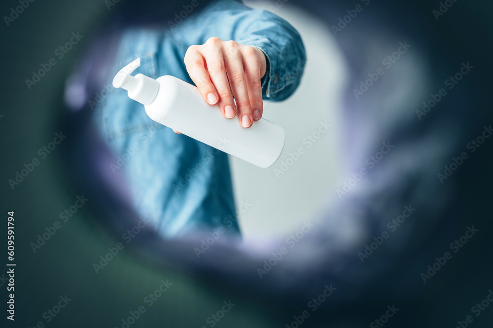 A female sorting a white package of shampoo or lotion into a bin. HDPE ...