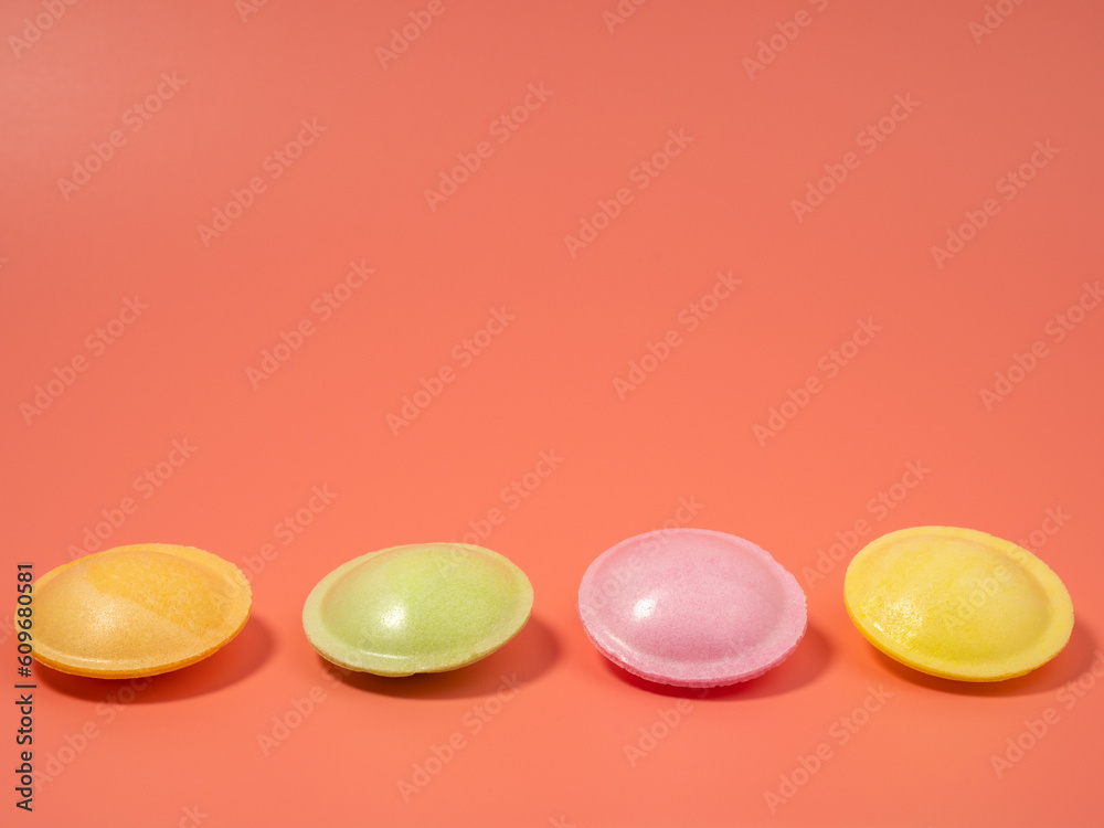 Sweet candies in the shape of a UFO in different colors on a pink ...