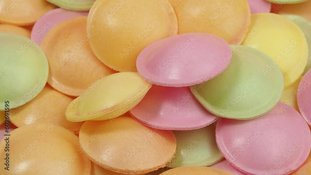 Sweet candies in the shape of a UFO in different colors rotate on a ...