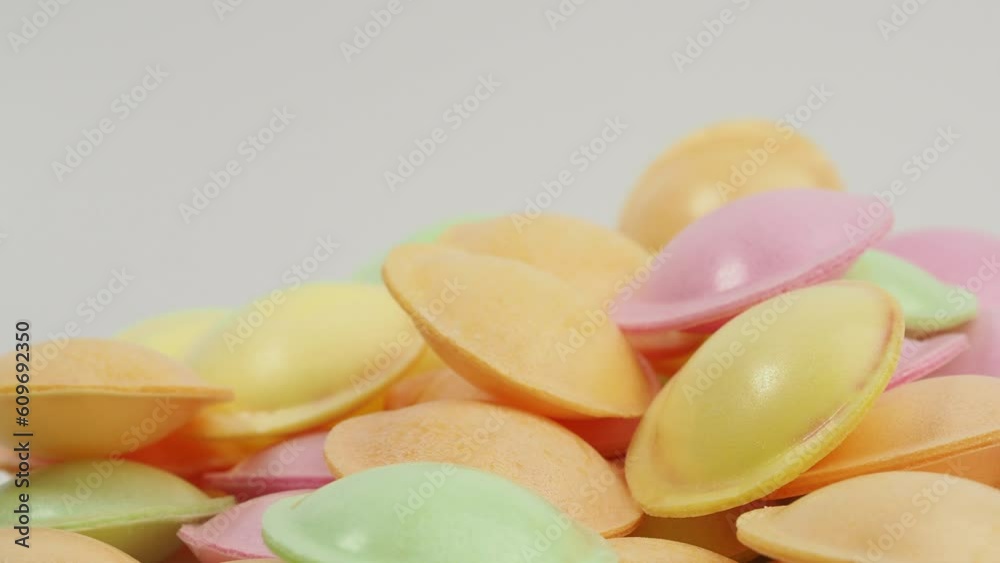 Sweet candies in the shape of a UFO in different colors rotate on a ...