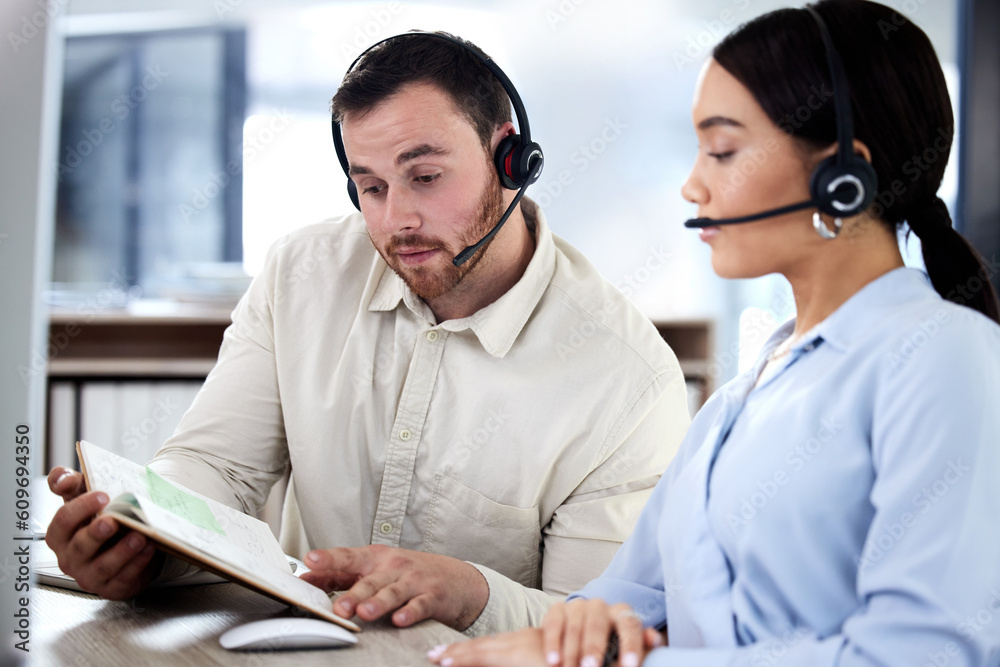 Call center, colleagues reading a notebook and headset at their desk in ...