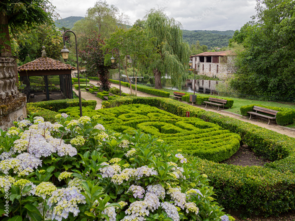 Paisaje de un laberinto de setos verdes en primer plano y árboles y ...