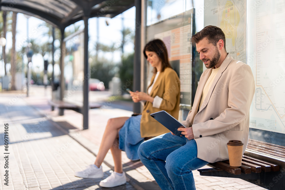 Fotka „Confident business man with takeaway coffee sitting at bus ...
