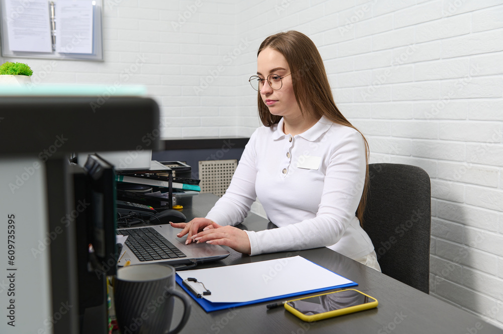 Confident female receptionist, office manager working on laptop ...