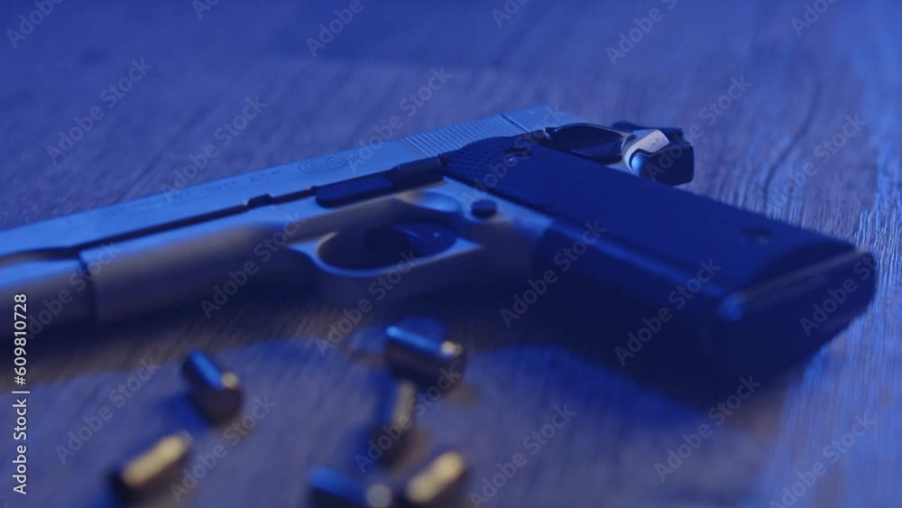 Dolly of a fired gun with spent bullet casings in a smoky crime scene ...