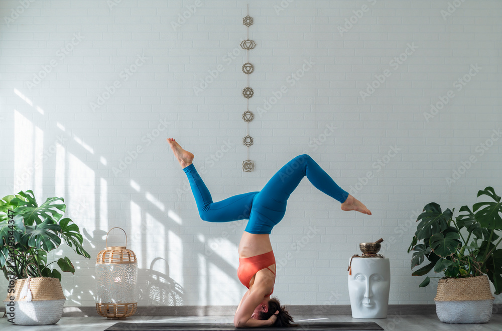 Woman doing supported headstand pose in front of wall Stock Photo ...