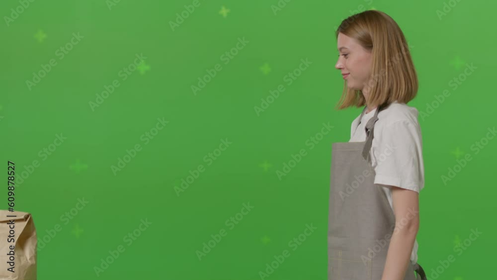 The waiter hands the package of food to the delivery man on green ...