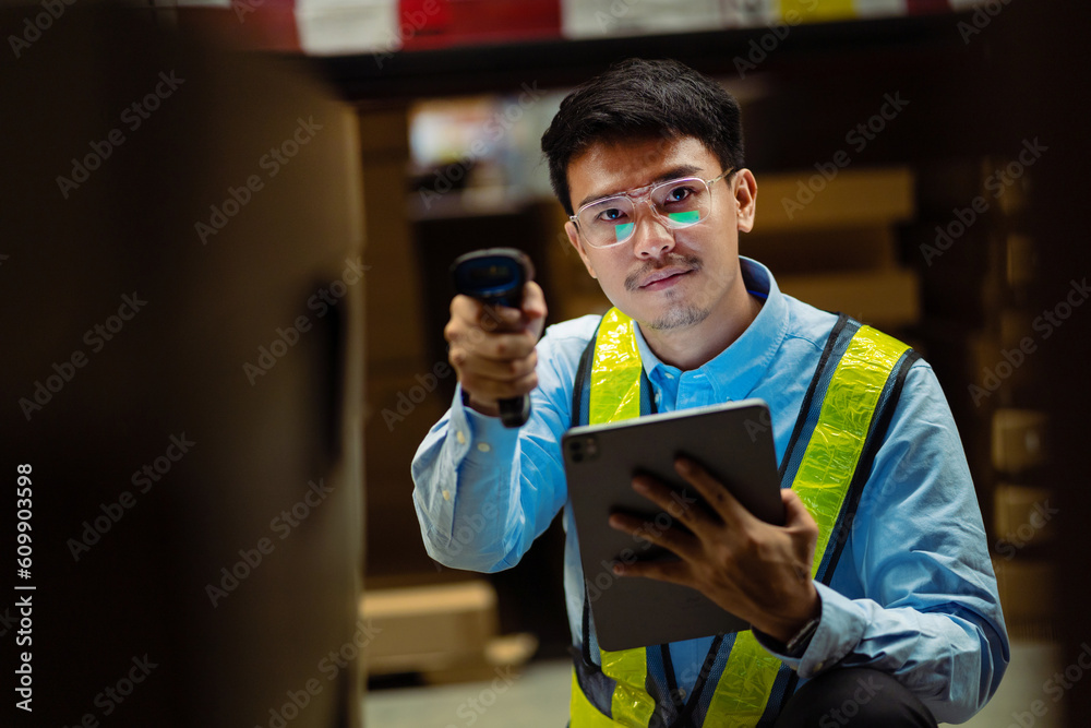 A warehouse worker is inspecting a cardboard box. Delivered in the ...