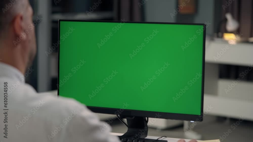 Man Working At Computer With Green Mock Up Screen in Home. Close Up ...