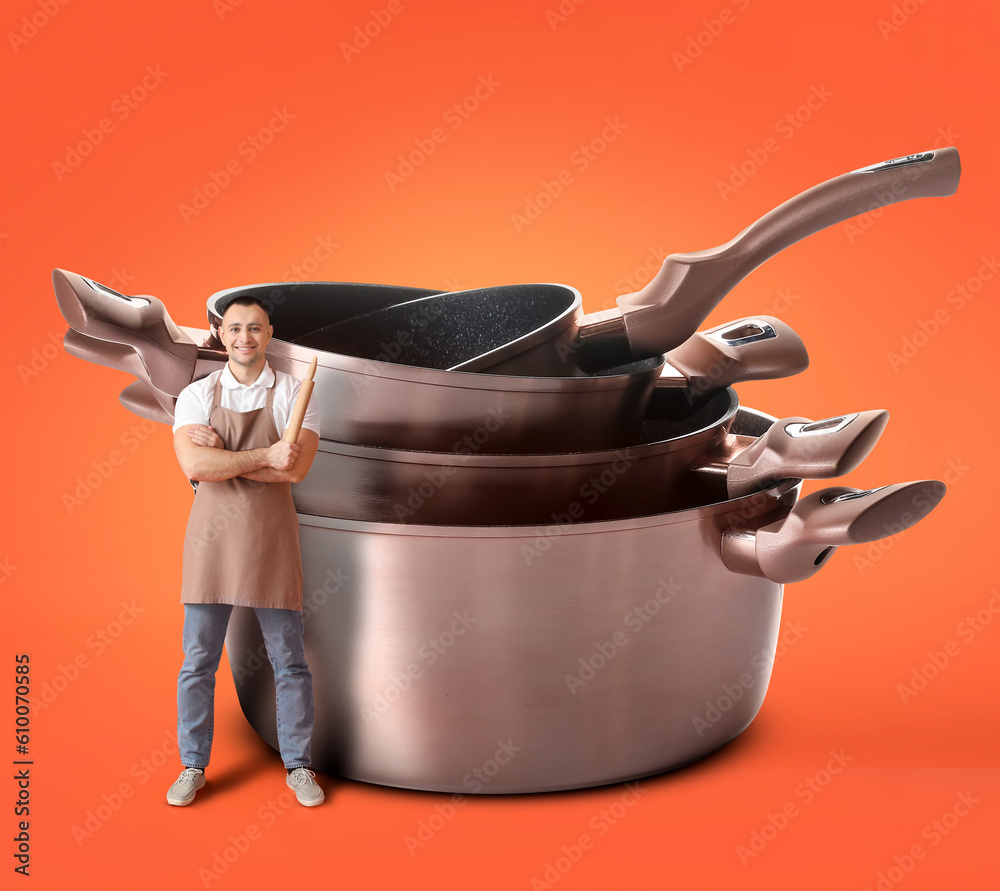 Handsome man with rolling pin and set of big cooking pots on orange ...