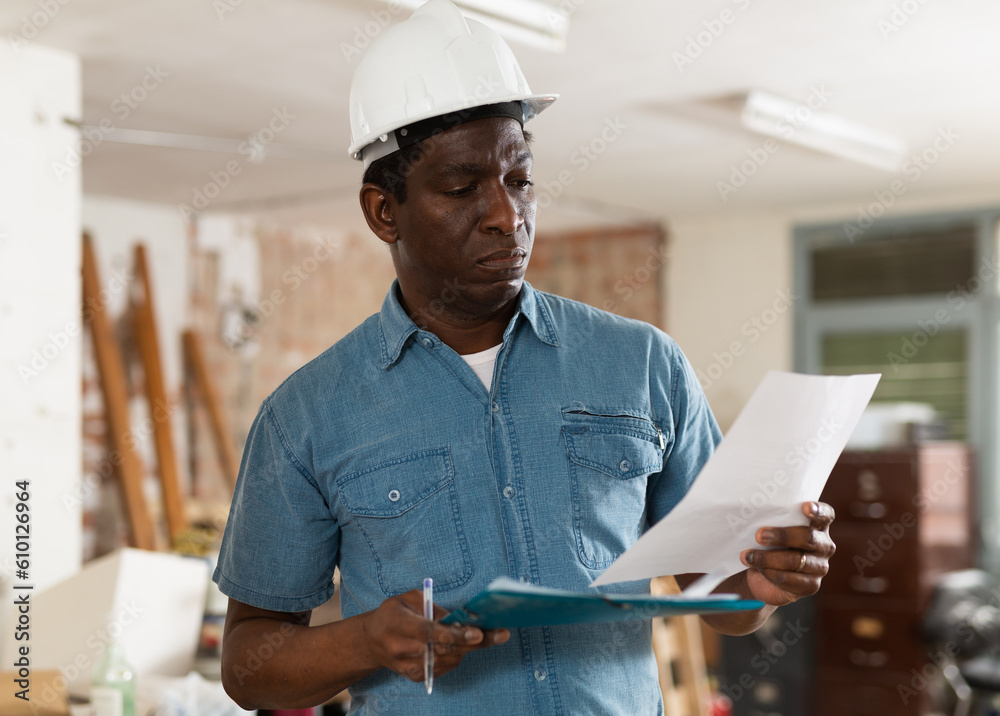 Strict focused african american building inspector wearing yellow ...