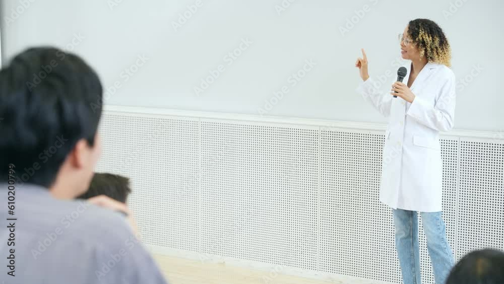 Female lecturer giving a lecture in the auditorium. University ...