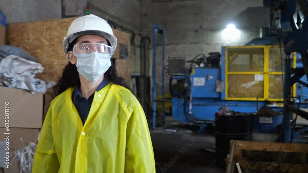 Black-haired lady inspector walks past conveyor belt transporting trash ...