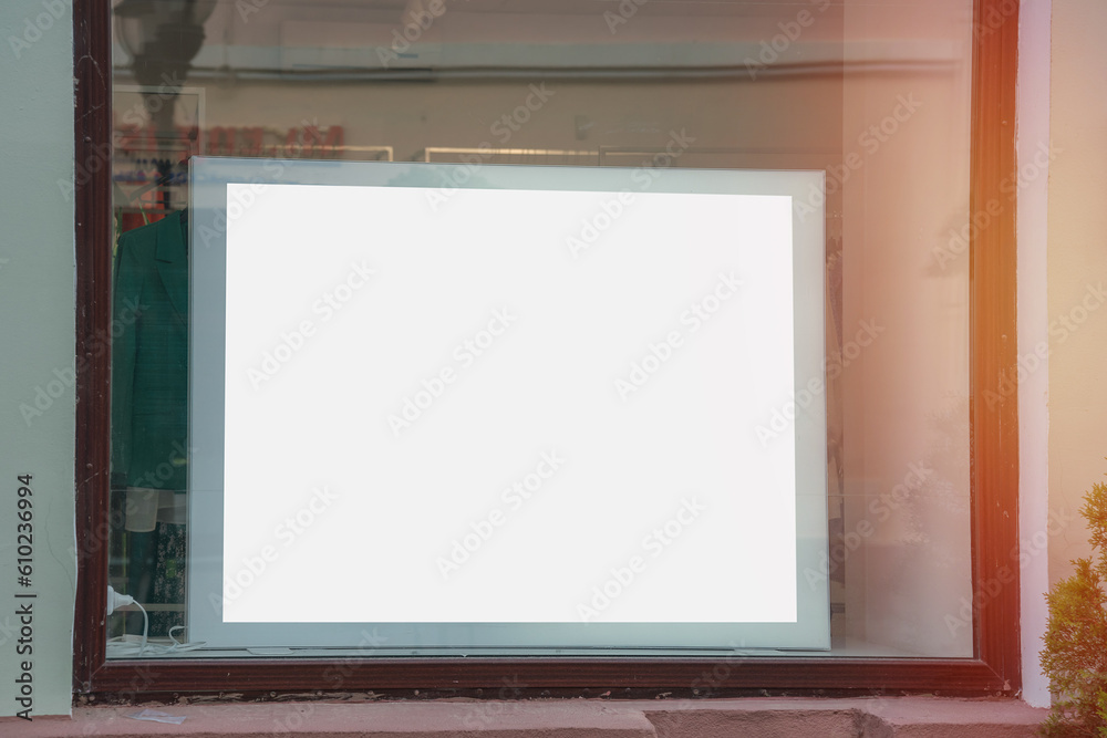 Large advertising white banner mounted behind window glass of fashion ...