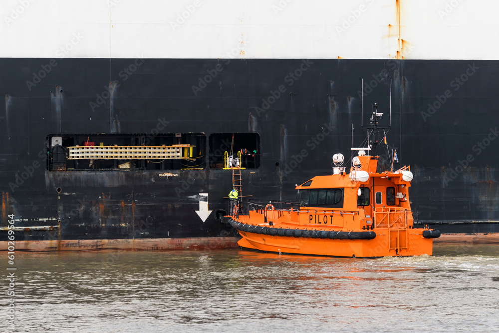 Pilot boat and cargo vessel at sea. Pilot embarkation. Pilotage. Stock ...