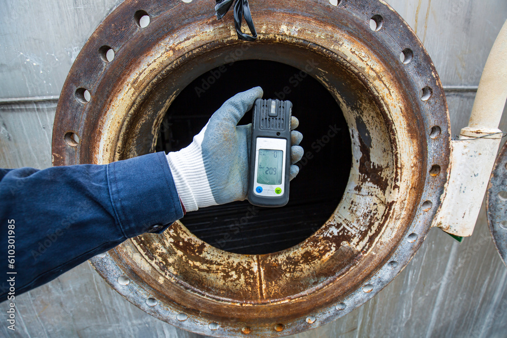 Worker hand holding gas detector inspection safety gas testing at front ...