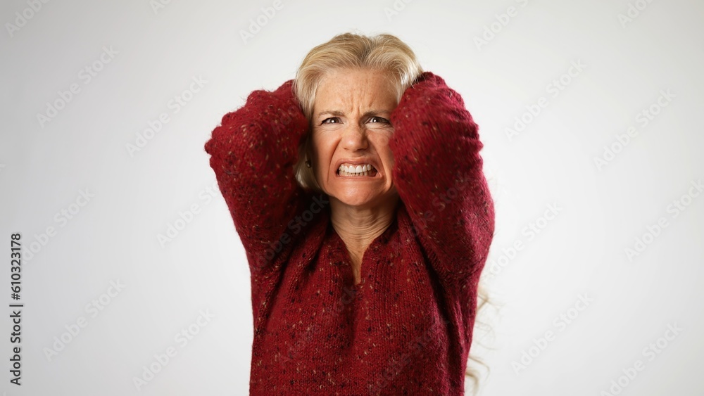 Portrait of pretty blond frustrated shaking head and pulling at hair ...