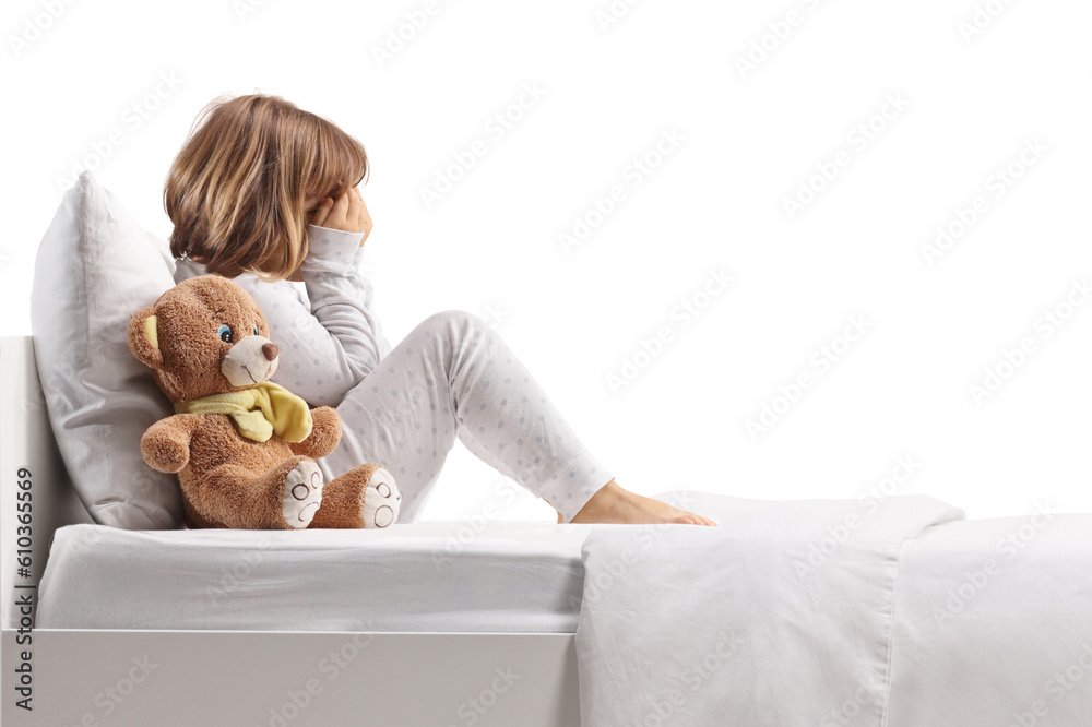 Sad girl in pajamas sitting on a bed and crying Stock Photo | Adobe Stock