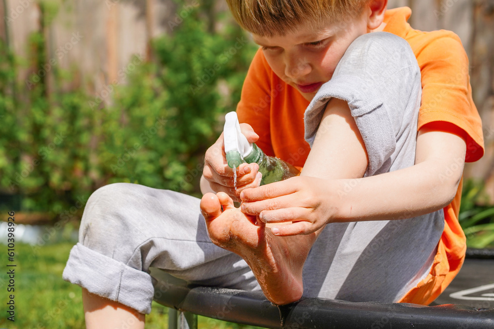 Young boy rinsing sand off his foot in garden. Summer vacation. Toddler ...