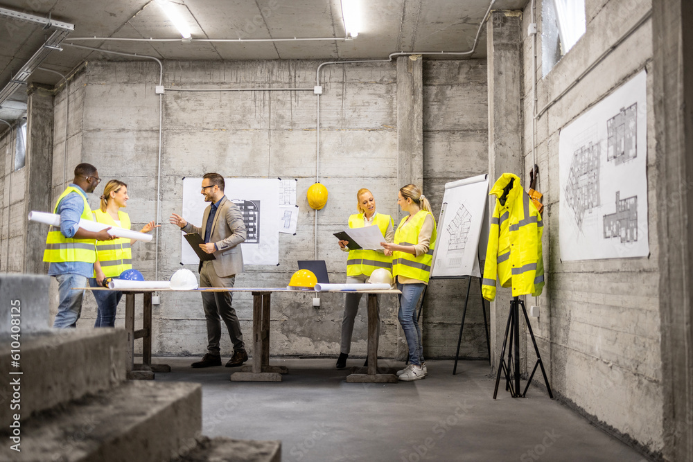 Contractor and architects analyzing plans and blueprints of the new ...