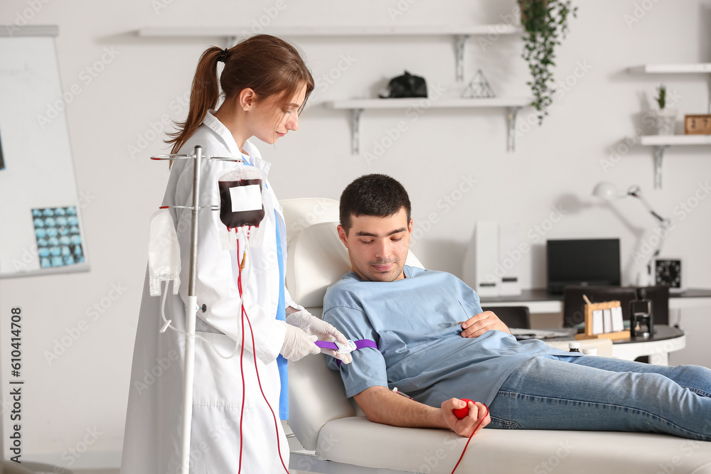 Female doctor taking blood from young donor in clinic Stock Photo ...