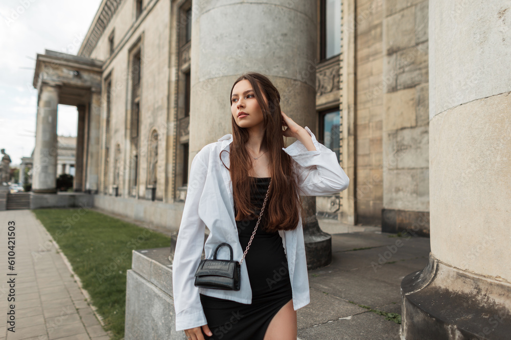 Beautiful young stylish chic girl model in a fashion black dress with a ...