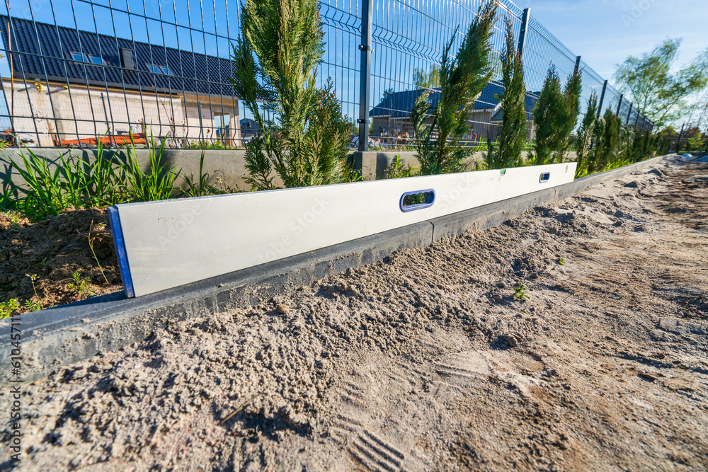 Building curb in the backyard using spirit level Stock Photo | Adobe Stock