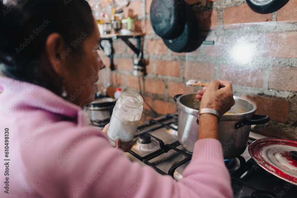 Mujer latina, adulto mayor ,en la cocina , picando, cortando verduras ...