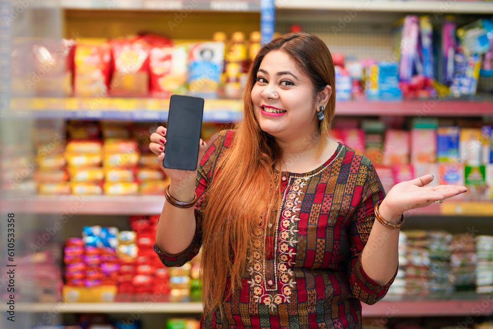 Indian woman showing smartphone screen at grocery shop. Stock Photo ...