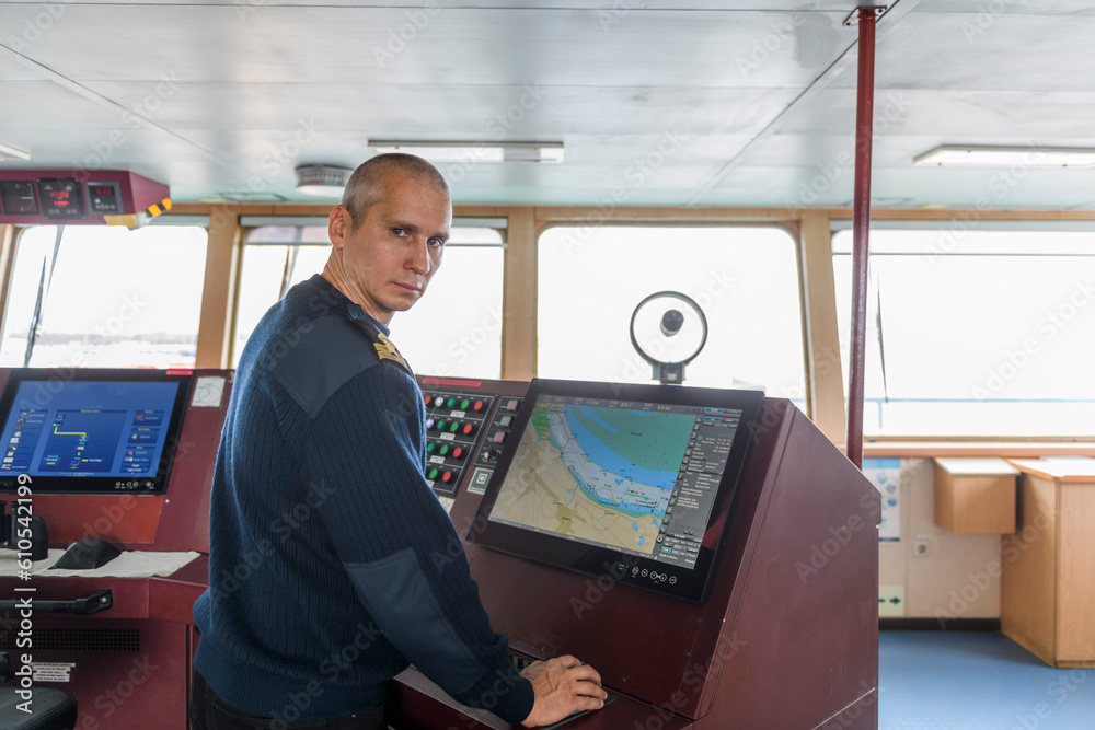 Officer on watch with electronic chart on the navigational bridge ...